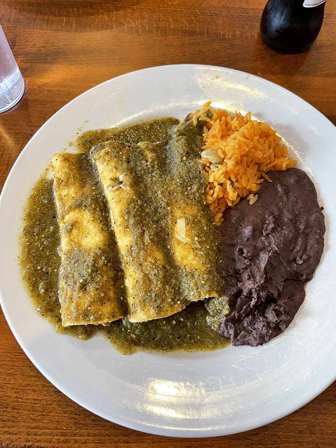 The green sauce enchiladas arrive like emeralds on a plate—a treasure of tomatillo tanginess swimming around corn tortillas stuffed with pure joy.