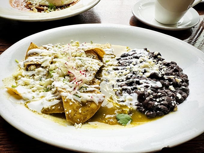 Chilaquiles verdes: where tortilla chips go for their spa treatment, emerging transformed by tomatillo sauce, crema, and black beans into breakfast nirvana.