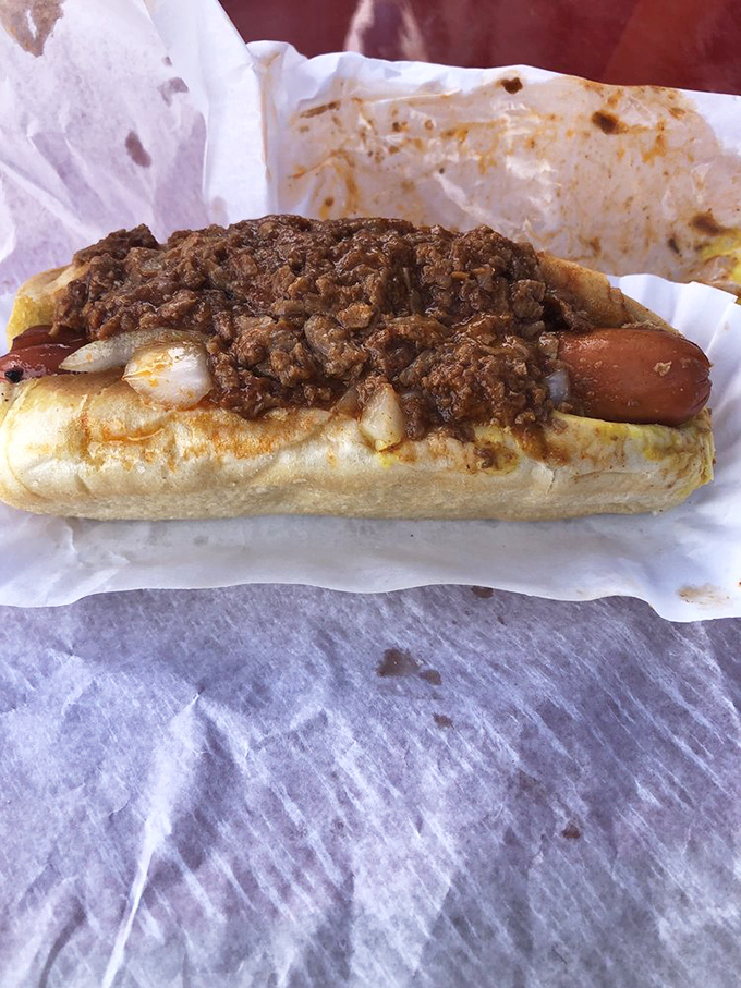 The star of the show in all its glory&mdash;a perfectly steamed bun cradling a snappy dog beneath a mountain of that legendary chili.