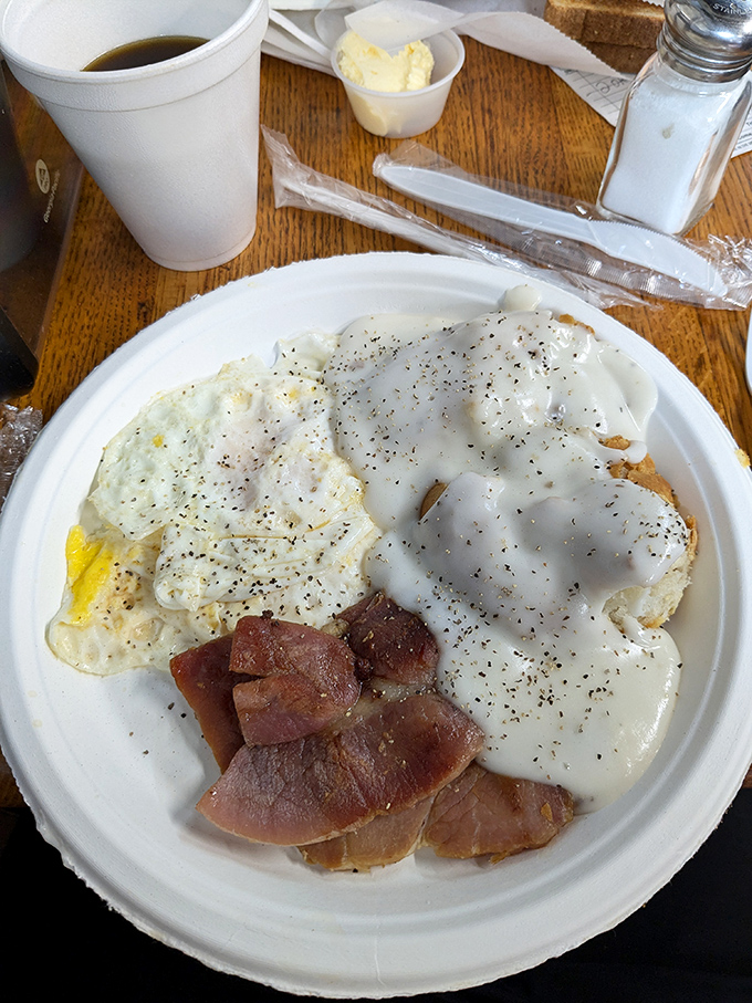 The holy trinity of breakfast perfection: farm-fresh eggs, thick-cut country ham, and gravy that could make a vegetarian reconsider.
