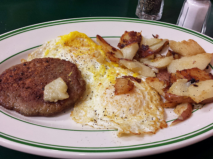 The holy trinity of breakfast: perfectly fried eggs, seasoned home fries, and a sausage patty that would make vegetarians question their life choices.