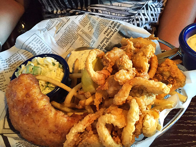 The basket arrives like edible beach treasure: golden clams and fish surrounded by fries, with coleslaw playing the cool, creamy counterpoint.