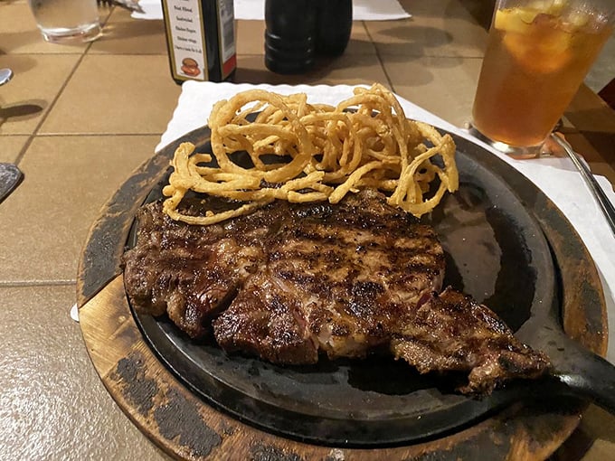 The cowboy steak arrives with crispy onion rings perched atop like a crown. Royalty doesn't always wear purple&mdash;sometimes it wears grill marks.