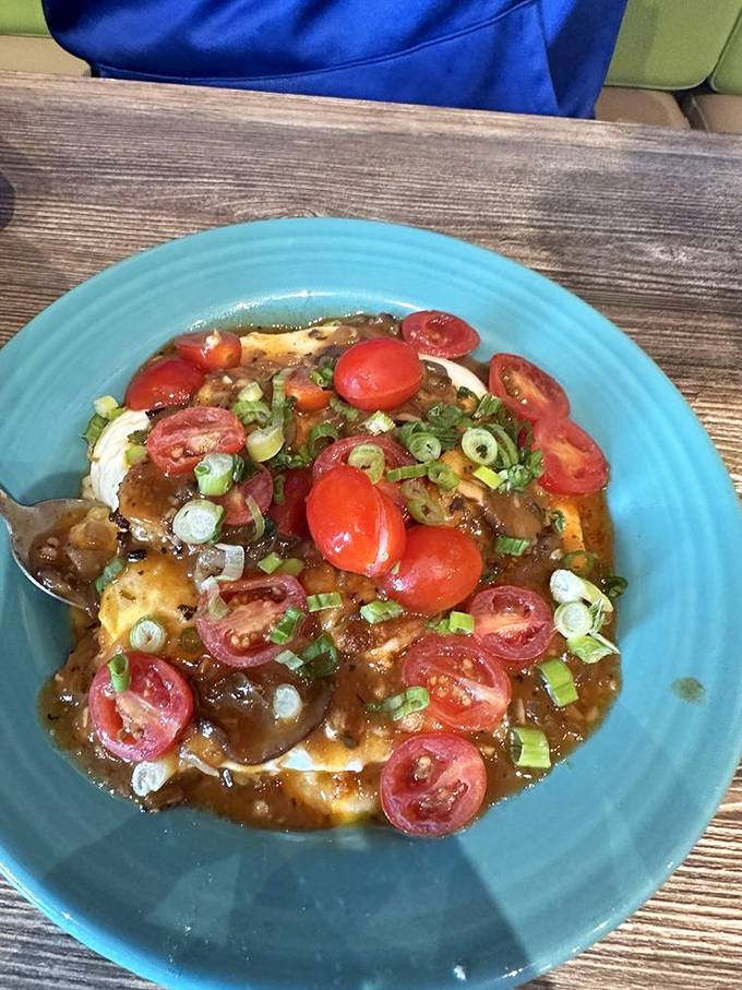 The holy trinity of breakfast perfection: creamy grits, succulent shrimp, and those fresh tomatoes adding pops of color and acidity.