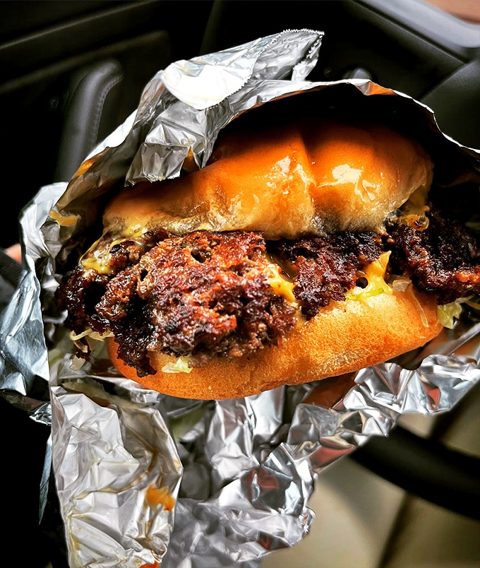 The double cheeseburger's lacy, crisp edges extend beyond the bun like a meat halo. Architectural perfection that would make Frank Lloyd Wright weep.