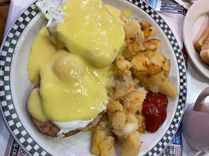 Eggs Benedict done right&mdash;hollandaise sauce cascading down like a yellow waterfall of happiness, with perfectly crispy potatoes standing by.