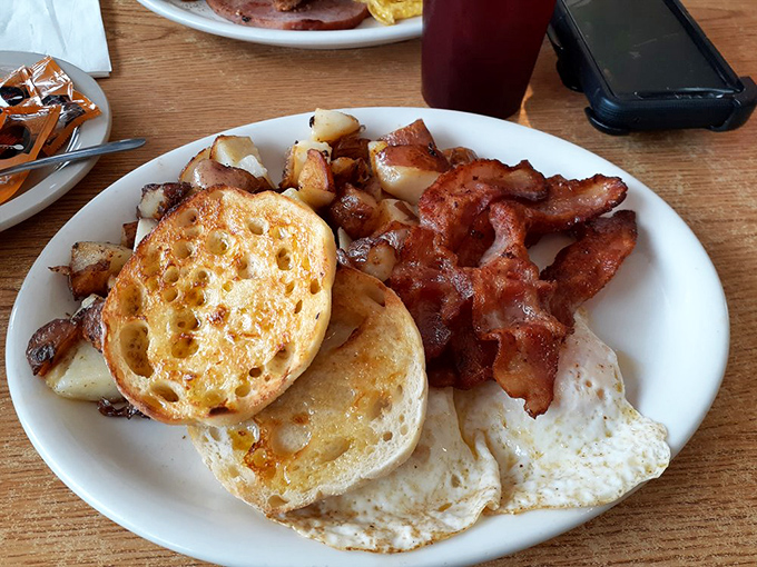 The holy trinity of breakfast perfection: crispy-edged eggs, bacon cooked to that ideal balance of crisp and chew, and golden-brown English muffins.