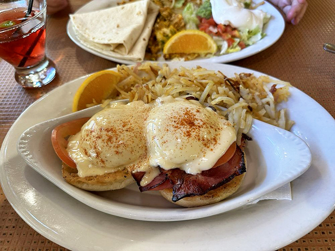 Eggs Benedict: where hollandaise dreams come true. The perfect poach meets savory bacon on an English muffin throne worthy of breakfast royalty.