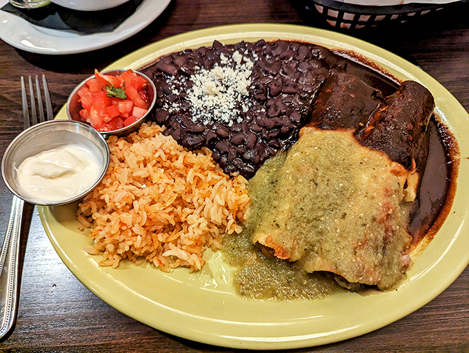 The holy trinity of Mexican comfort: perfectly spiced rice, velvety beans, and an enchilada wearing its green sauce like a royal robe.