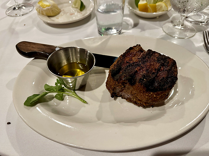 The filet mignon sits regally on its plate, a testament to simplicity. That golden butter sauce isn't showing off &ndash; it's just doing what generations of steakhouse chefs know works.