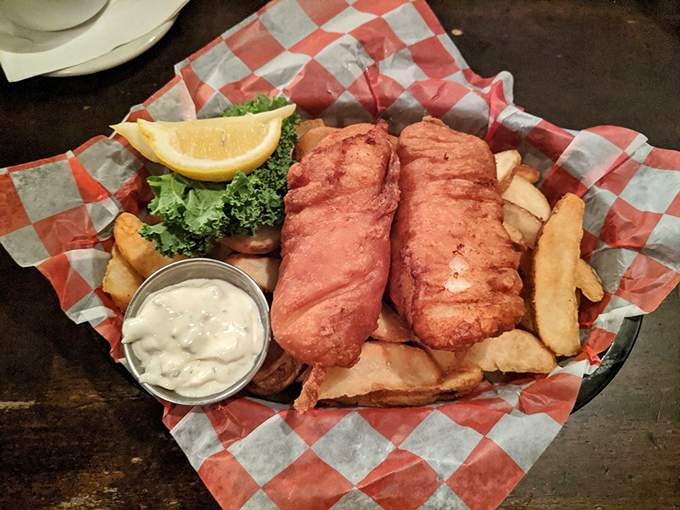 Two perfectly crisp cod fillets stand at attention beside their potato companions, while tartar sauce waits patiently for its moment of glory.