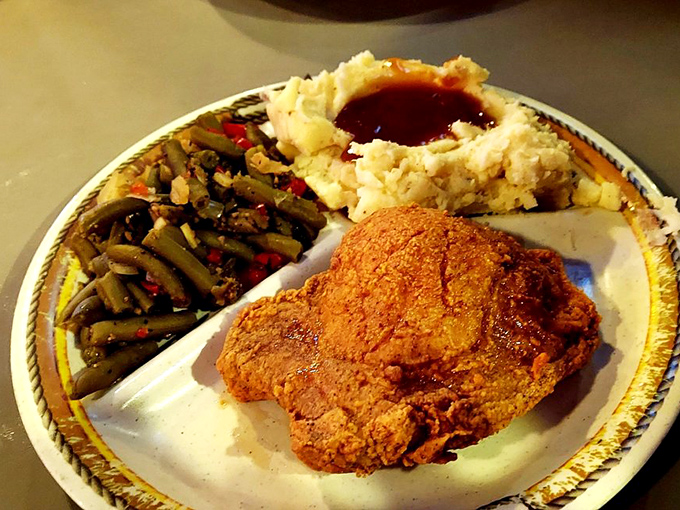Comfort food trifecta: A crispy fried porkchop sharing the spotlight with buttery mashed potatoes and seasoned green beans. Happiness has a plate.