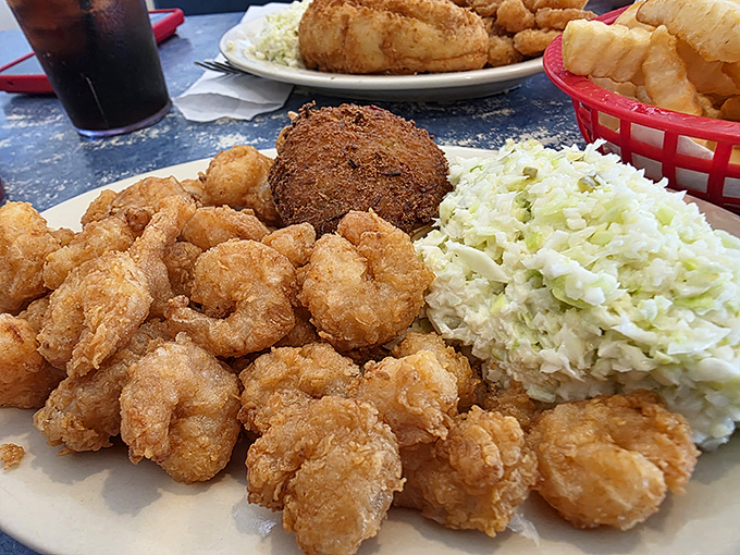 The holy trinity of Calabash dining: perfectly fried shrimp, creamy coleslaw, and what appears to be a deviled crab cake. Heaven exists on a white plate.