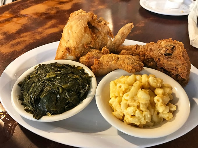The holy trinity of Southern comfort: perfectly fried chicken, collard greens cooked to silky submission, and mac and cheese that could make a cardiologist nervously reconsider their career choice.