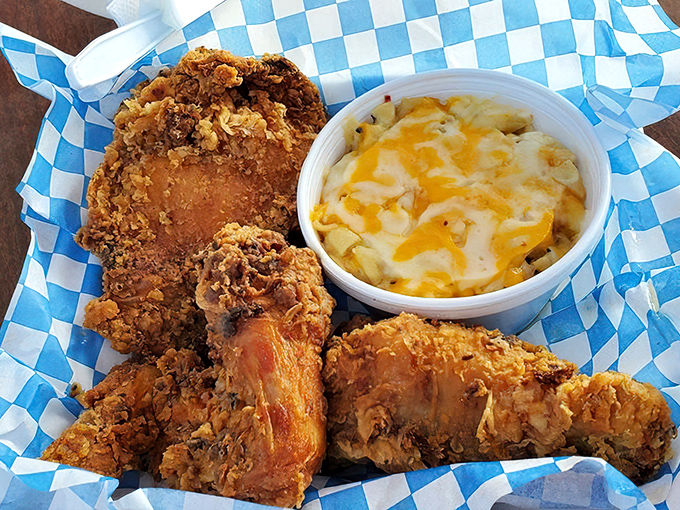 The holy trinity of comfort: perfectly fried chicken, mac and cheese with that crusty cheese top, and a checkered paper that says "we mean business."