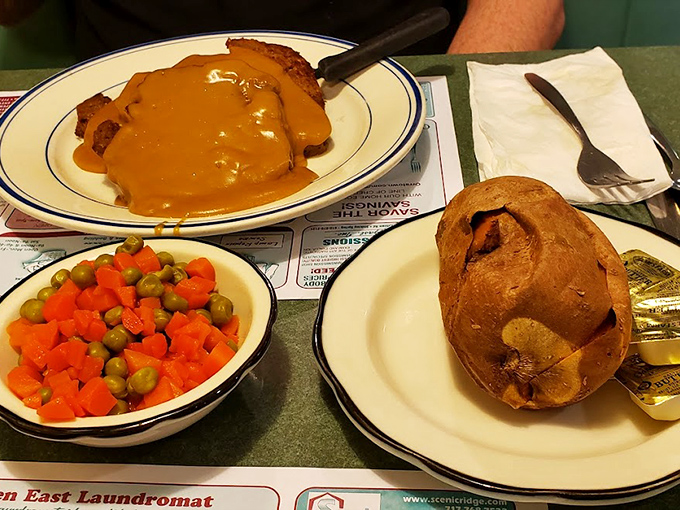 Gravy shouldn't just be poured&mdash;it should cascade like this golden waterfall over perfectly cooked meat. That baked potato and vegetable medley aren't afterthoughts; they're essential supporting characters.