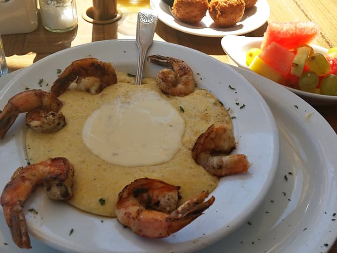 The shrimp and grits arrive like edible artwork – plump crustaceans standing guard around a creamy castle of Southern comfort.