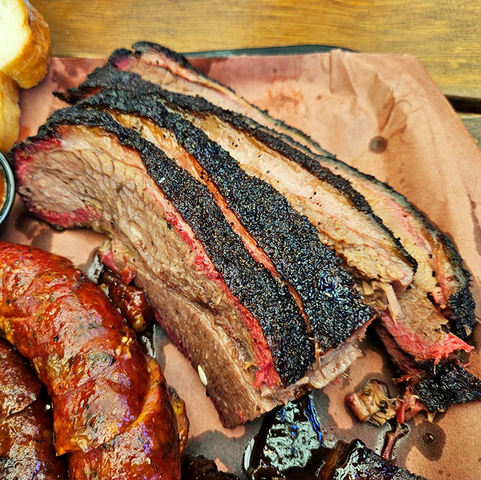 The holy trinity of barbecue perfection: bark, smoke ring, and tender meat. Add pickled onions and sauce, and you've got a religious experience on butcher paper.