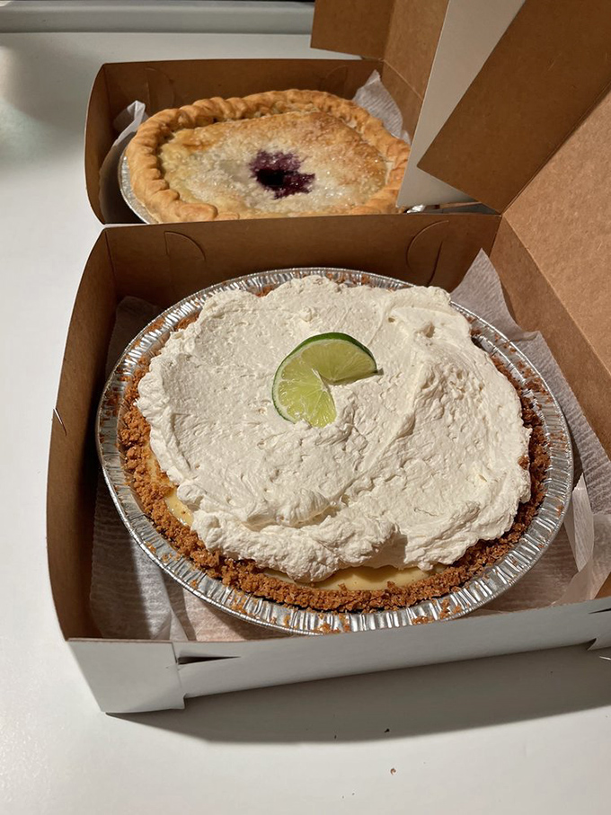 Key lime pie with a lime slice crown sits regally above its blueberry companion&mdash;a diplomatic solution to dessert indecision.