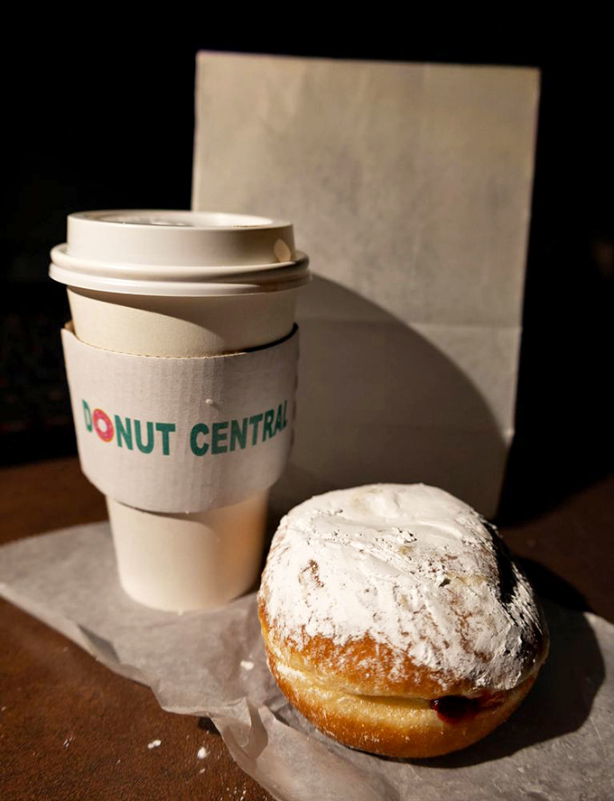 The powdered Bismark sits regally beside its coffee companion. Like a snow-capped mountain of deliciousness waiting to reveal its raspberry heart.