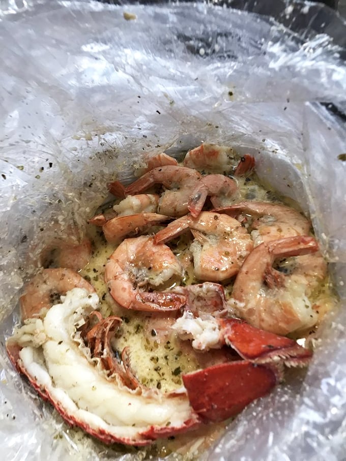 Inside this plastic bag lies a buttery revelation—lobster and shrimp swimming in seasoned goodness that would make Neptune himself jealous.