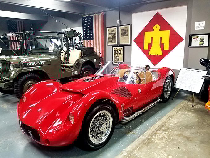 The fierce red Maserati Tipo 61 sits ready for action beneath American flags &ndash; Italian engineering with enough curves to make a mountain road jealous.