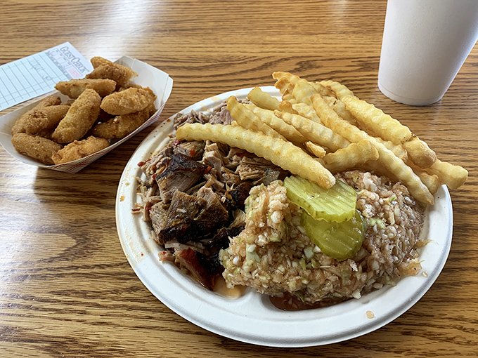The holy trinity of Lexington barbecue: smoky pork, vinegar-tinged red slaw, and crispy fries. A plate that speaks North Carolina's dialect fluently.