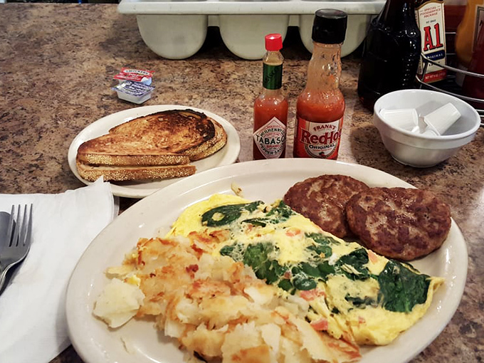 Spinach and feta transform ordinary eggs into something Mediterranean grandmothers would approve of. Those sausage patties look like they're auditioning for a meat calendar.