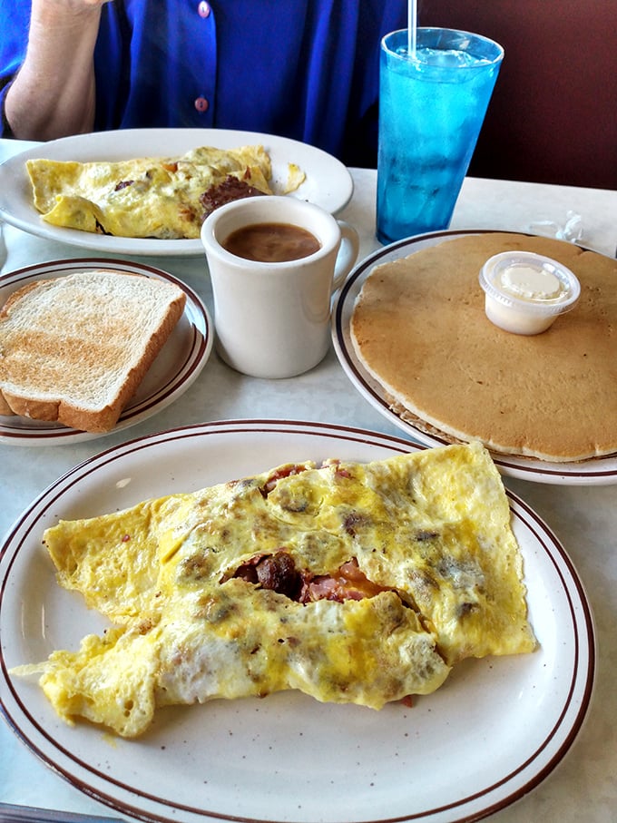 This isn't just an omelet; it's a masterclass in egg architecture. Fluffy exterior, treasure-filled interior, with pancakes standing by.