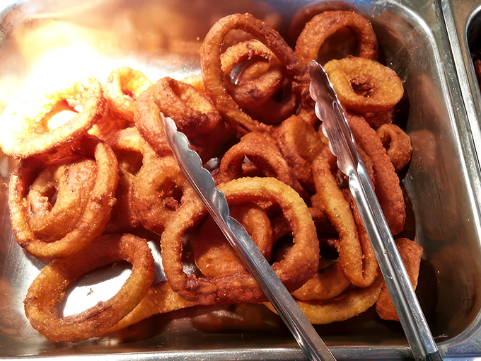 Golden onion rings piled high like delicious life preservers, ready to rescue you from hunger's stormy seas.
