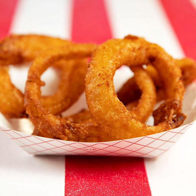 These onion rings aren't just side dishes—they're golden halos of crispy perfection that deserve their own moment of silence.