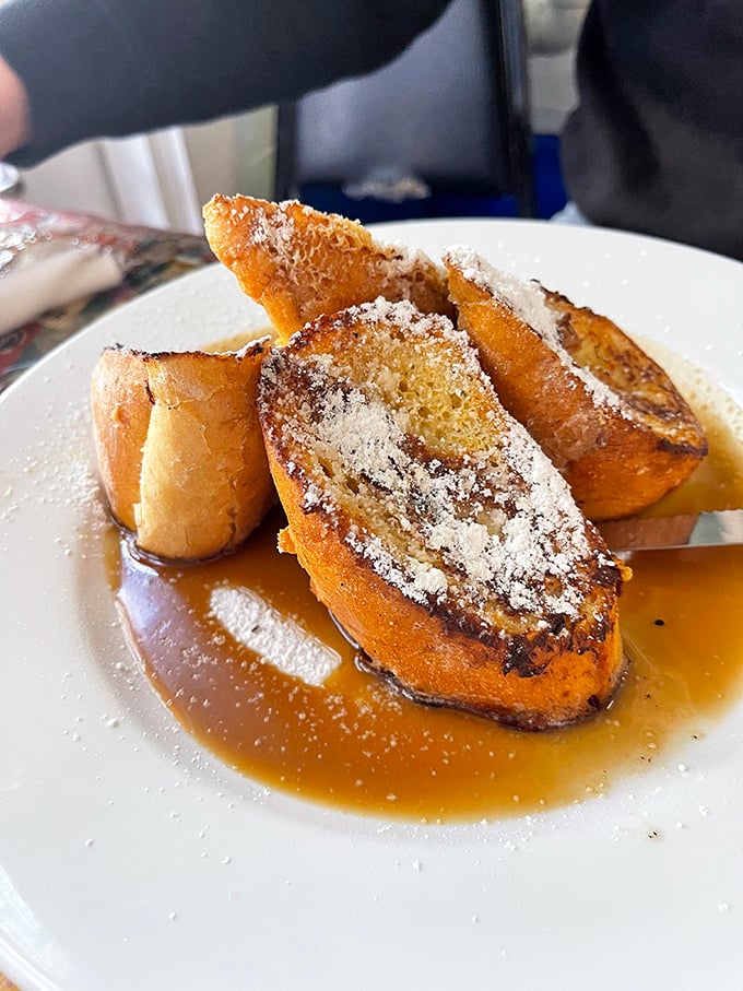 Pain Perdu elevated to art form &ndash; bread soaked in custard until surrendering completely, then baptized in syrup and powdered sugar for heavenly results.
