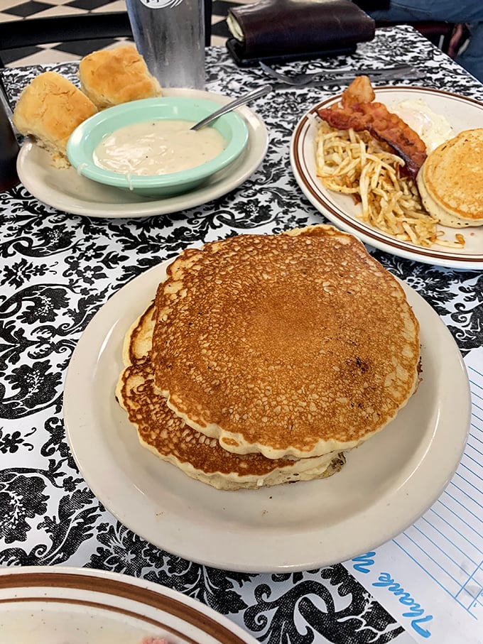 Pancakes so perfectly golden they deserve their own sunrise. Those biscuits and gravy in the background are plotting a delicious takeover.