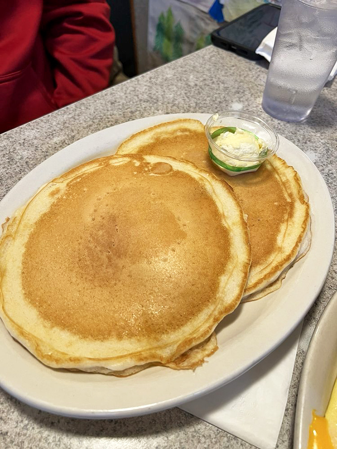 These golden pancakes aren't just breakfast, they're edible frisbees of joy &ndash; served with a modest puddle of butter that knows exactly what you need.