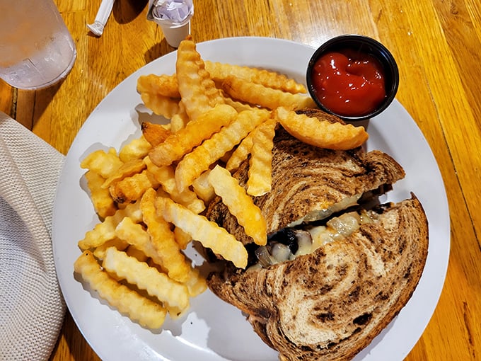 Comfort food perfection: a golden-grilled patty melt with crispy crinkle-cut fries. Simple pleasures that transcend time and trends.