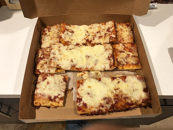 The cheese pull on this square slice could win Olympic medals. Miami's answer to the eternal question: how much cheese is too much?