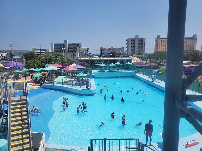 The main pool area buzzes with activity, while colorful umbrellas stand guard against the sun that makes this oasis necessary in the first place.