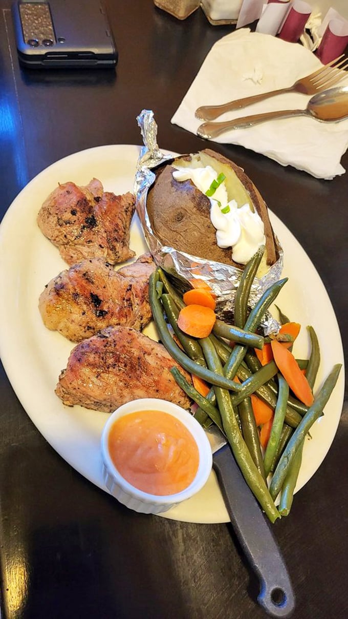 The holy trinity of comfort: perfectly seasoned pork tenderloin, a loaded baked potato, and fresh vegetables that actually taste like vegetables.