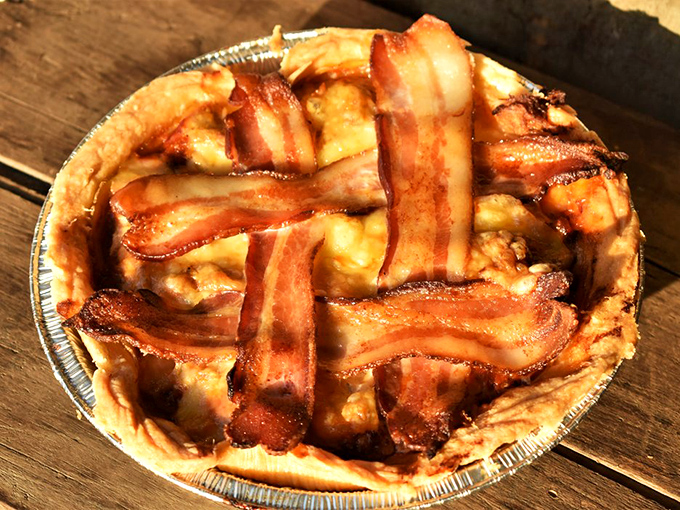 Bacon lattice work that would make architectural digest jealous, covering a pulled pork pie that redefines savory indulgence.