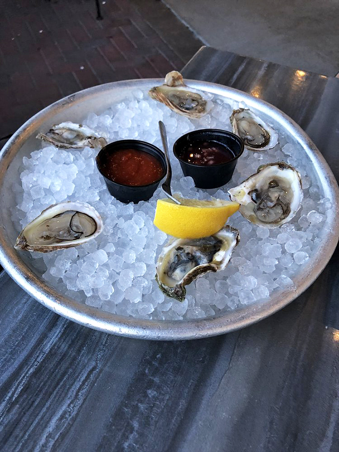 Fresh oysters nestled in ice tell stories of distant shores, each briny morsel a perfect miniature ocean served with classic accompaniments.
