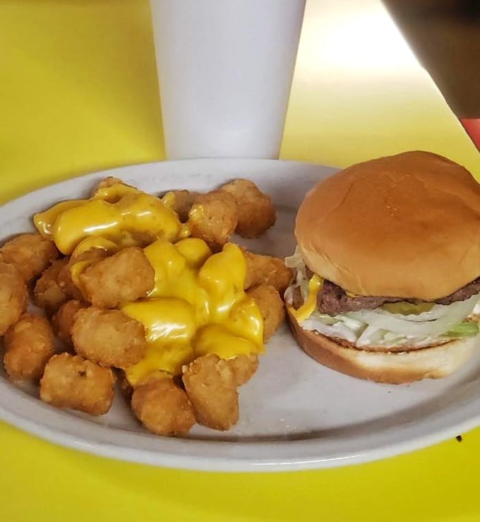 Cheese cascading over tots like a yellow waterfall meeting its potato destiny. The burger stands by, wondering why it isn't getting all the attention.