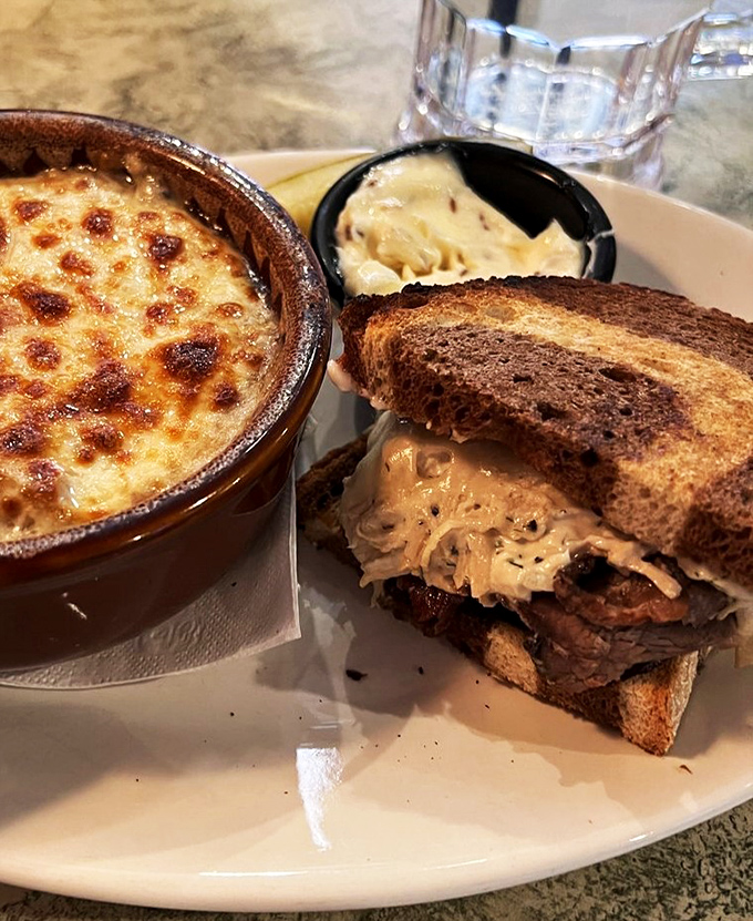 The ultimate power couple: a hearty Reuben sandwich alongside bubbling French onion soup. Comfort food diplomacy at its finest.