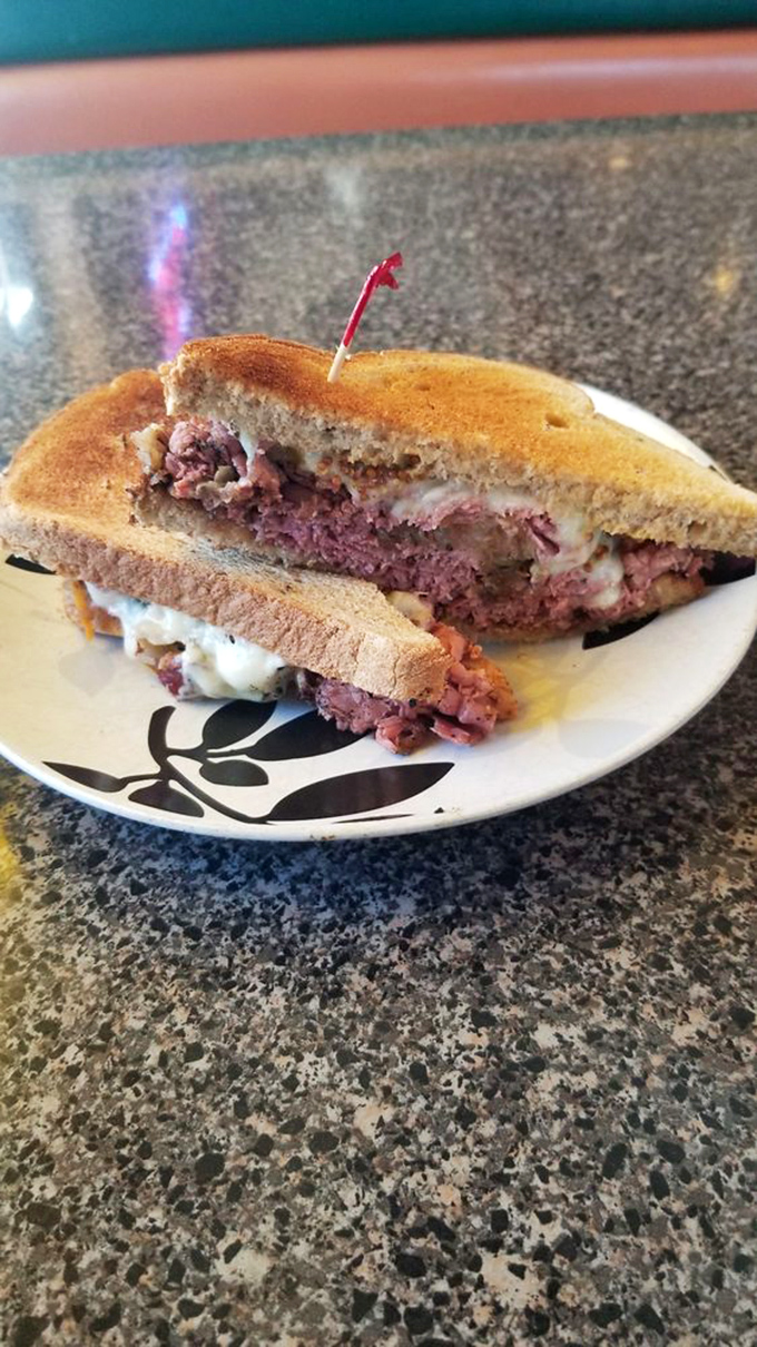 The Reuben in its natural splendor – a perfect balance of corned beef, melted Swiss, and toasted rye that demands a moment of respectful silence.