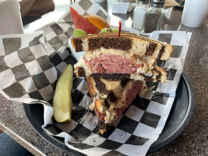 The perfect cross-section reveals the Reuben's architecture&mdash;layers of meat, sauerkraut, and melted Swiss creating the Taj Mahal of sandwich experiences.