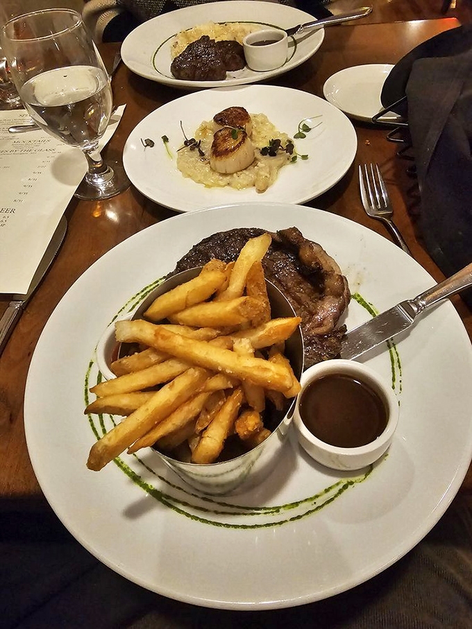 A triumvirate of deliciousness&mdash;steak with golden fries, scallops nestled on creamy risotto, and another cut waiting in the background. Decisions, decisions.