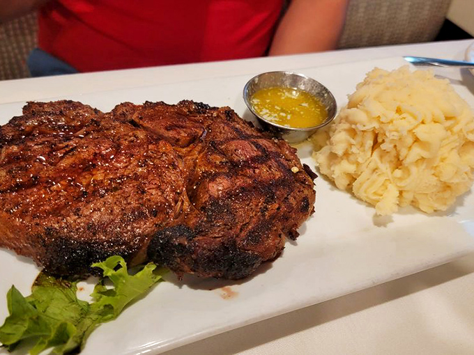 The ribeye arrives like a carnivore's dream, accompanied by mashed potatoes so fluffy they could double as a pillow if you fall into a food coma.