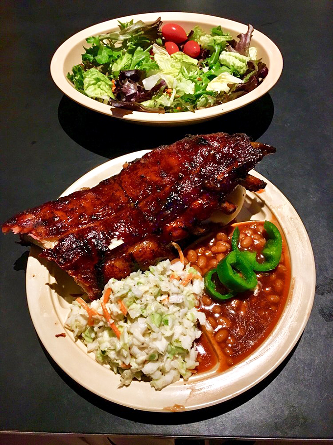 A rack of ribs shares the spotlight with fresh coleslaw and beans, while jalape&ntilde;os add a touch of green to this symphony of smoke.