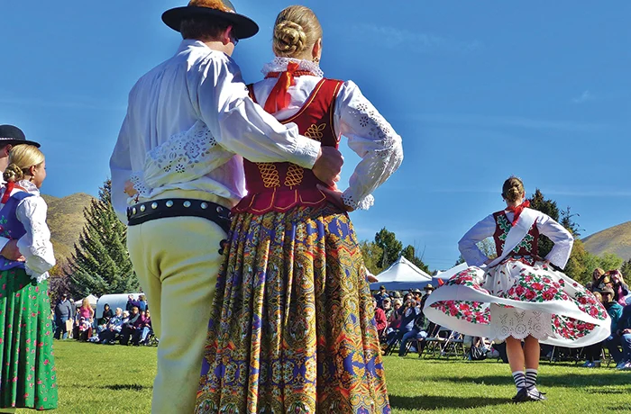 Classic cars gather outside a historic brick building, a time-traveling car show that would make Jay Leno reach for his keys.