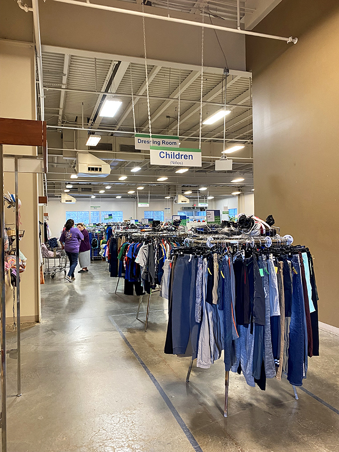 Serious shoppers navigate the children's section with the focus of archaeologists on a dig. Every rack holds potential discoveries!