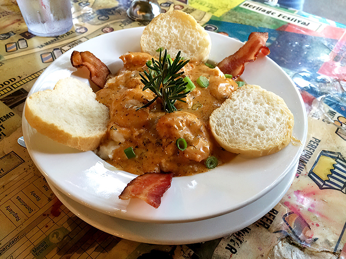 The holy trinity of breakfast perfection: buttery grits, succulent shrimp in Cajun-spiced sauce, and crusty French bread for sopping up every last drop.